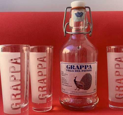 Стопки "grappa" и пустая бутылка"grappa"