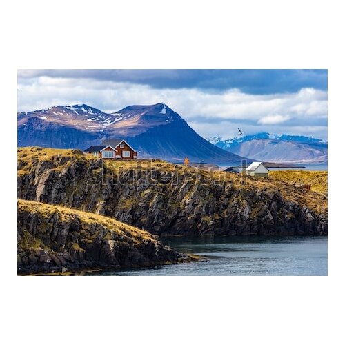 Постер на холсте Великолепный исландский пейзаж с домами на фоне величественных гор в историческом городе Стиккисхоульмюр (Исландия) 45см. x 30см.
